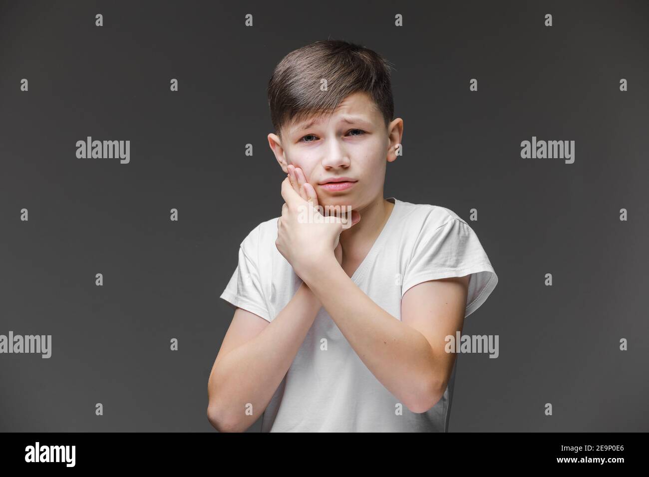 Child toothache. holding his cheek, dental pain. Closeup portrait boy ...
