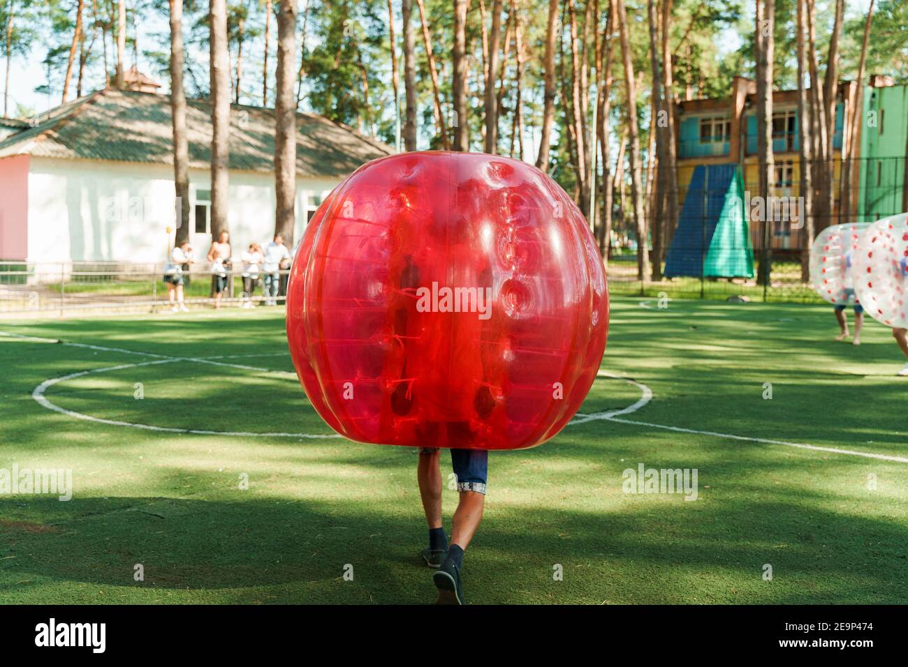 Bubble football sport game. Football players play bumperball on the ...