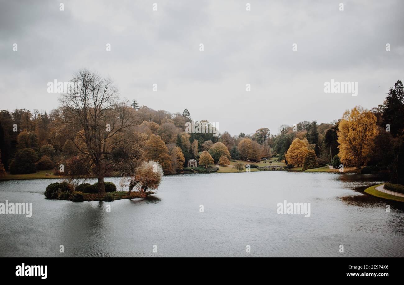 Majestic nature scene of a small reflective lake surrounded by colorful ...