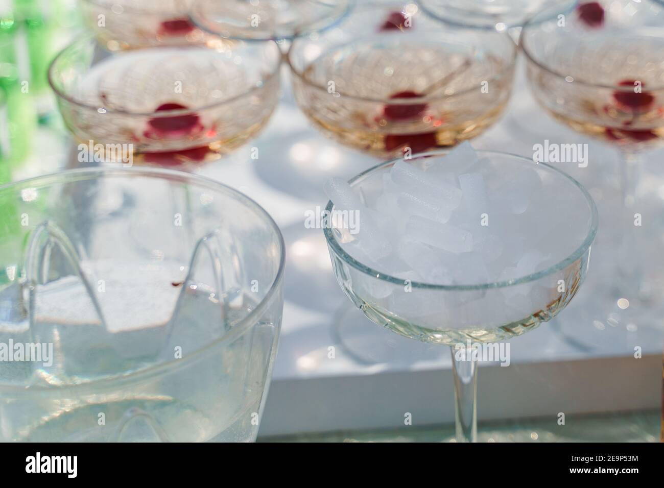 Dry ice cubes in glass cup close-up near pyramid of champagne. Dry ice ...