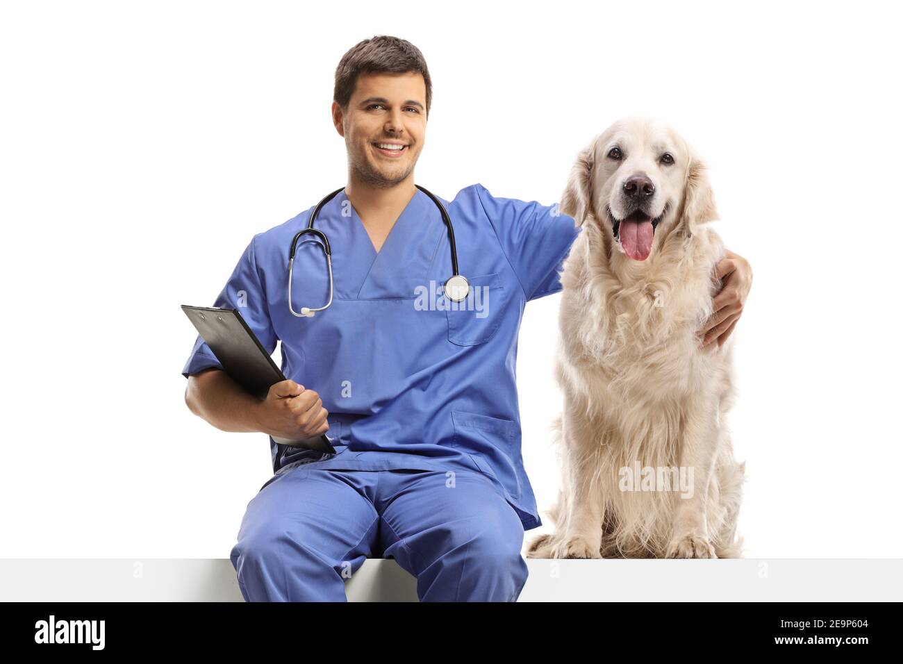 Veterinarian doc in a blue uniform sitting on a white panel and hugging ...
