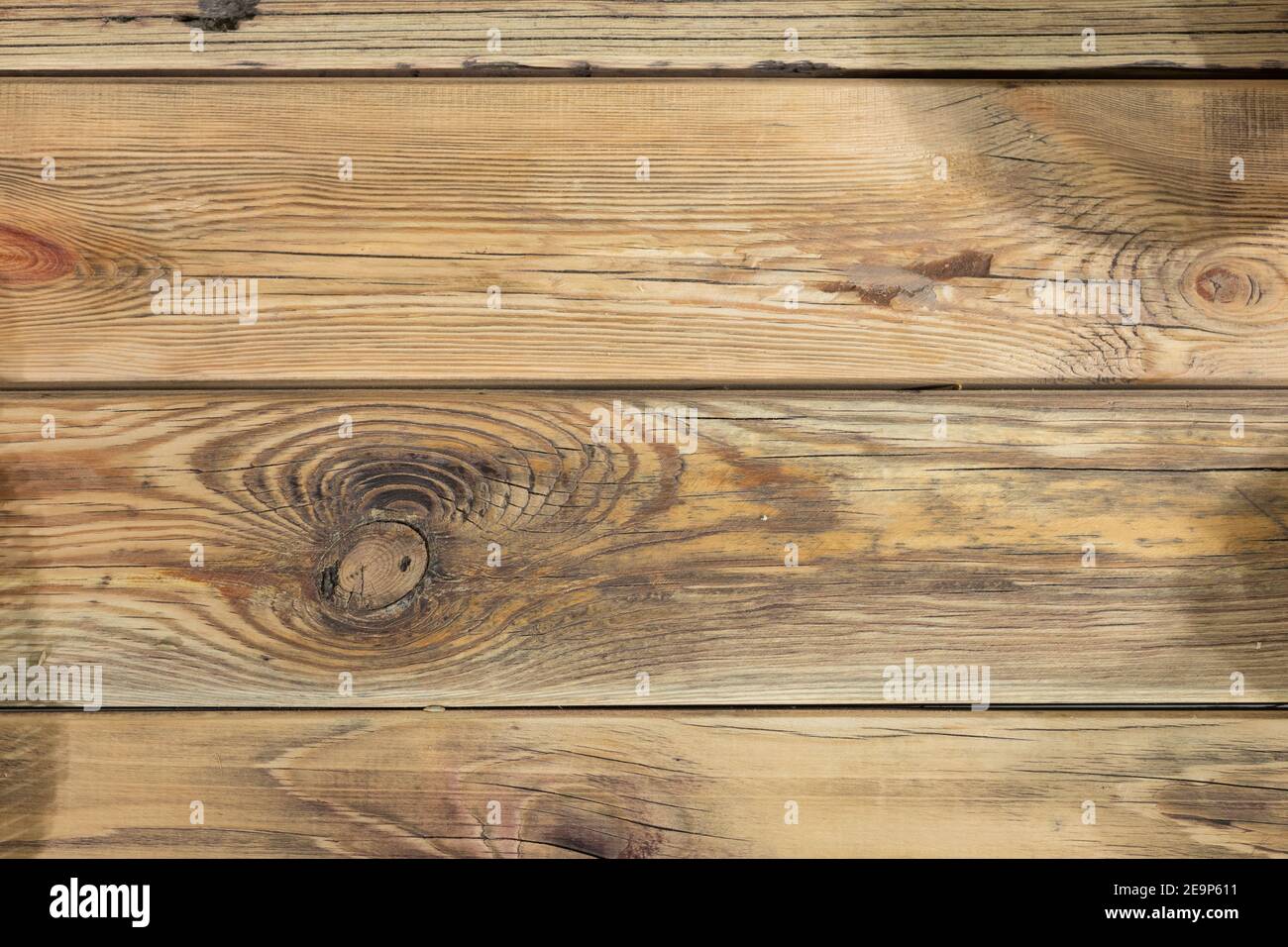 Planks stacked next to each other, each of them is old and cracked, and ...