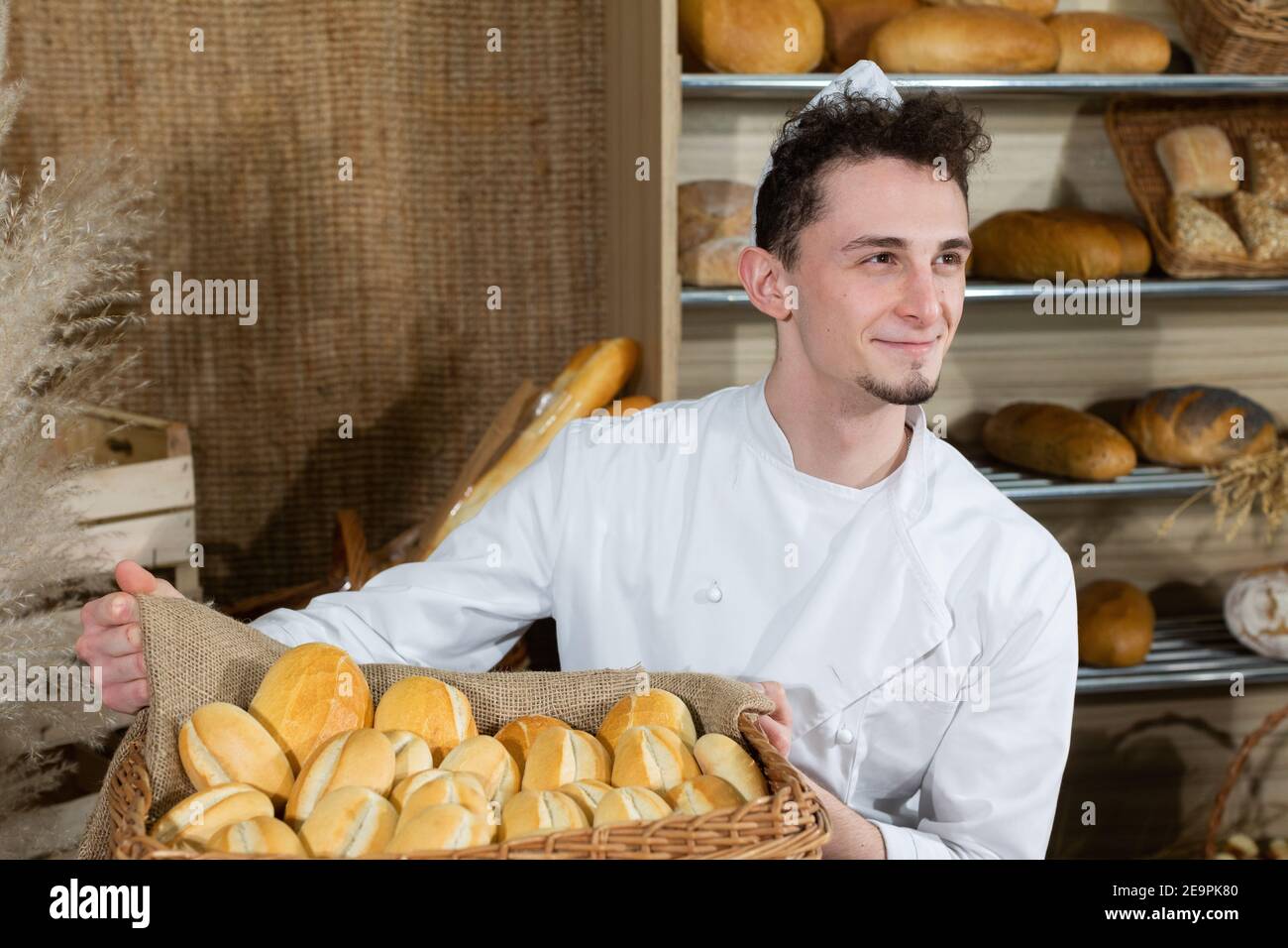 A clerk sits behind the counter serving his own baked goods. A handsome ...