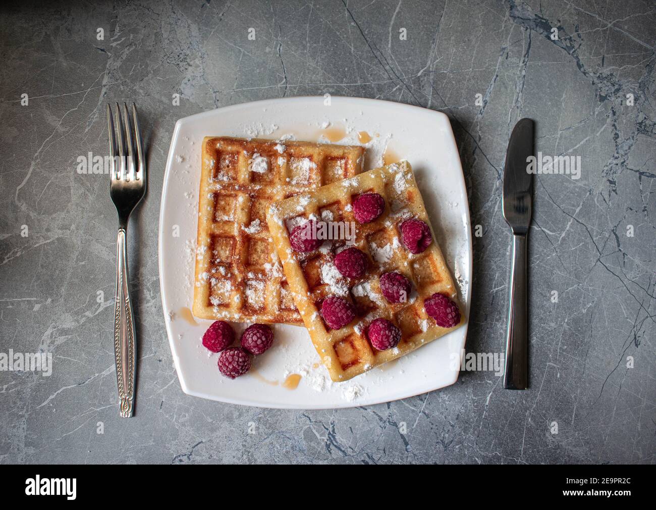 Overhead view of waffles at a table with cutlery Stock Photo - Alamy