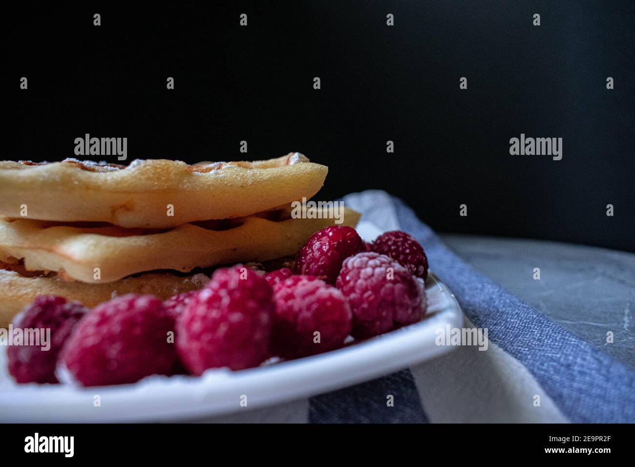 Side view of waffles and raspberries Stock Photo - Alamy