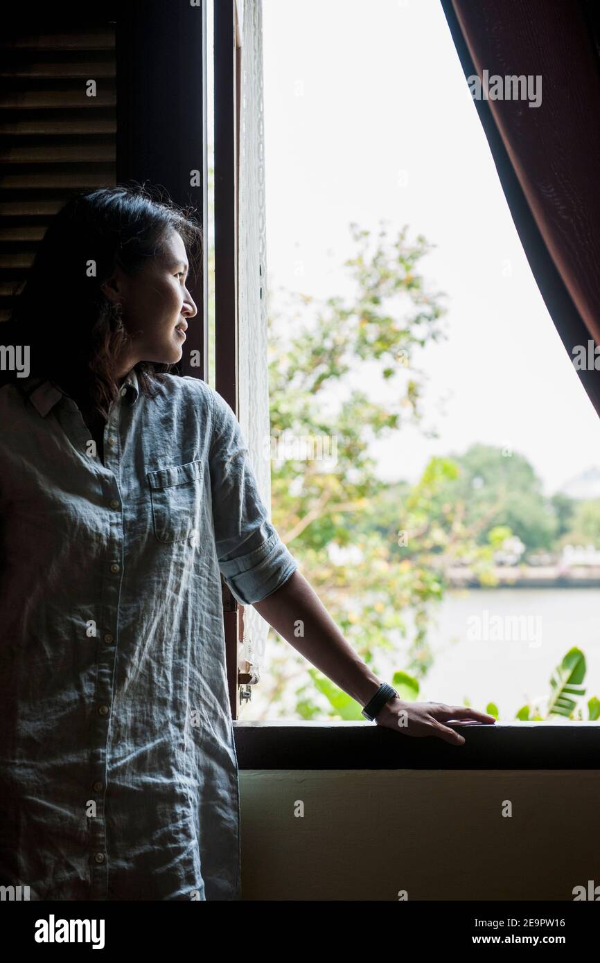 beautiful woman looking out of window in Bangkok Stock Photo - Alamy