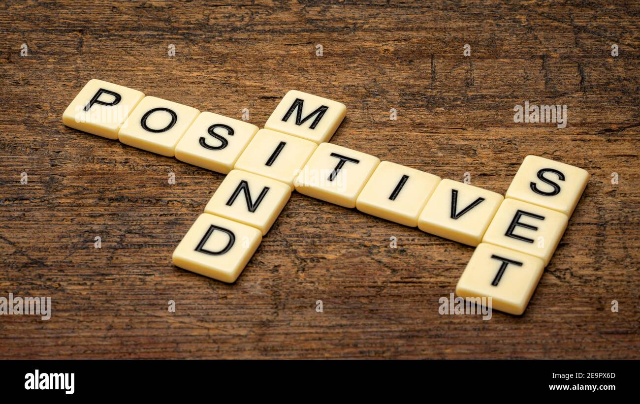 positive mindset crossword in ivory letter tiles against rustic wood ...
