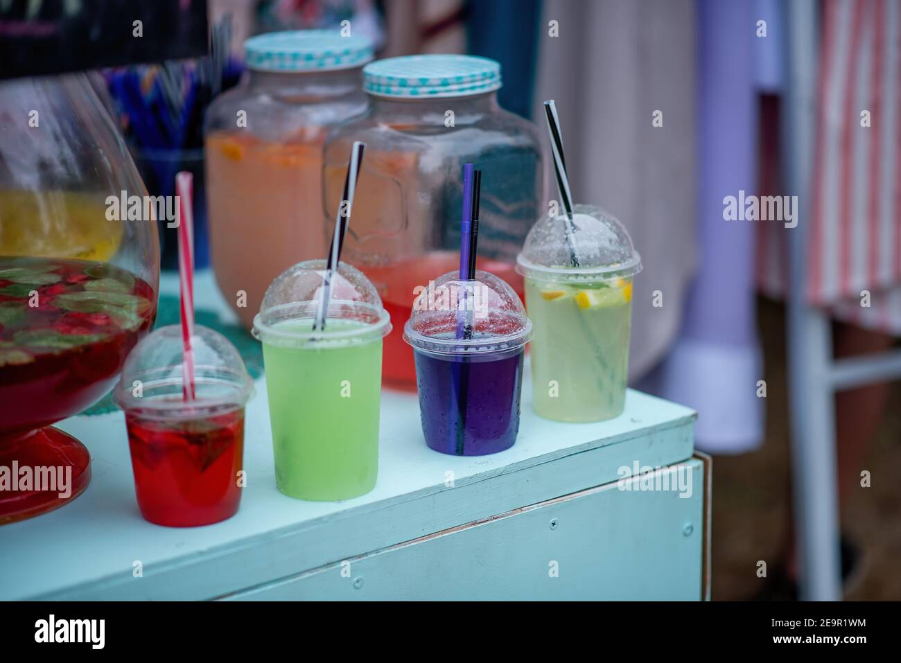 At a street food festival, colorful cocktails are displayed on the ...