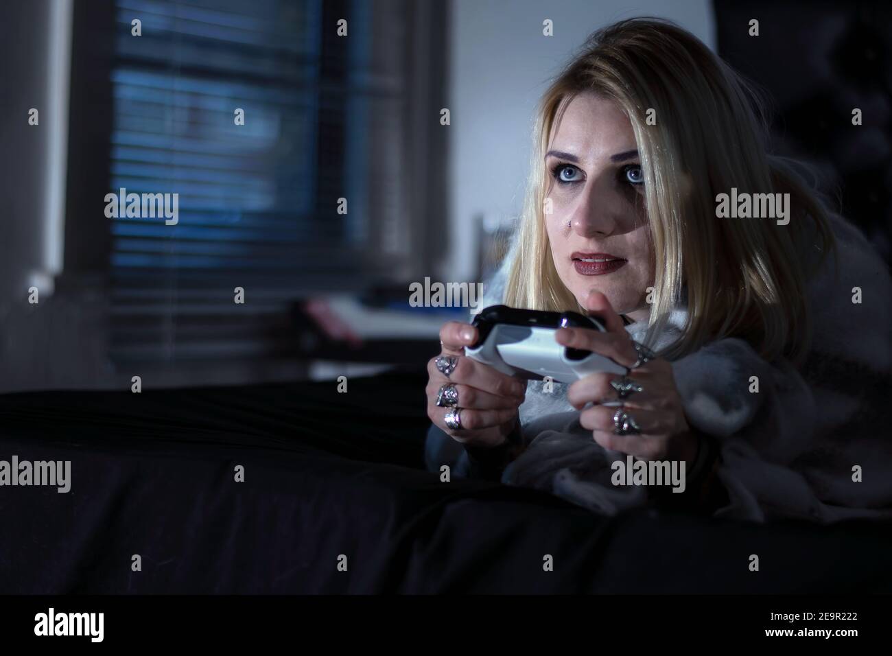Woman playing a video game at night on the bed Stock Photo - Alamy