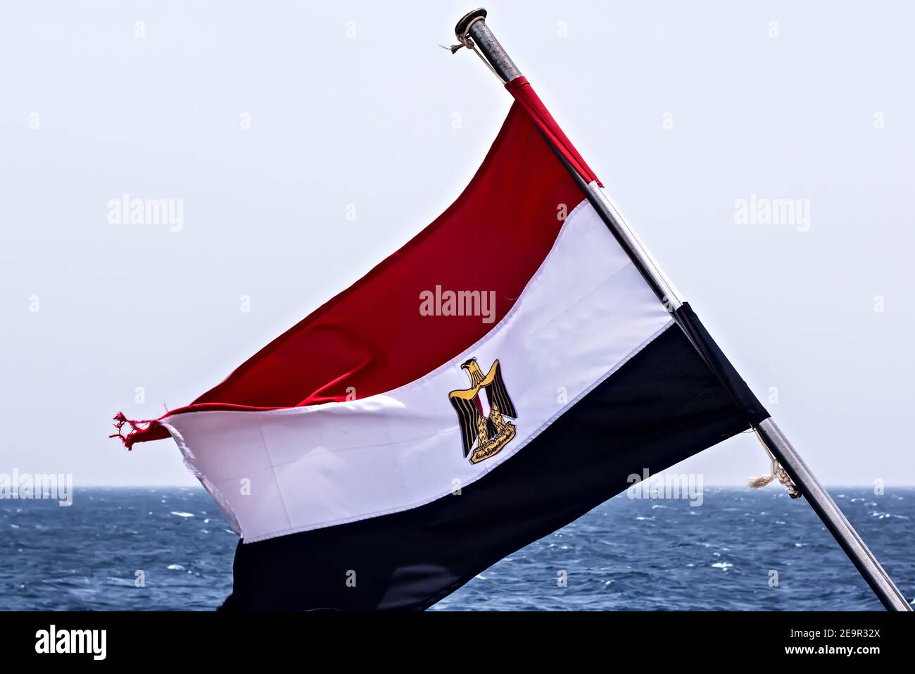 Egypt national flag waving on the wind of blue sky background. The flag ...