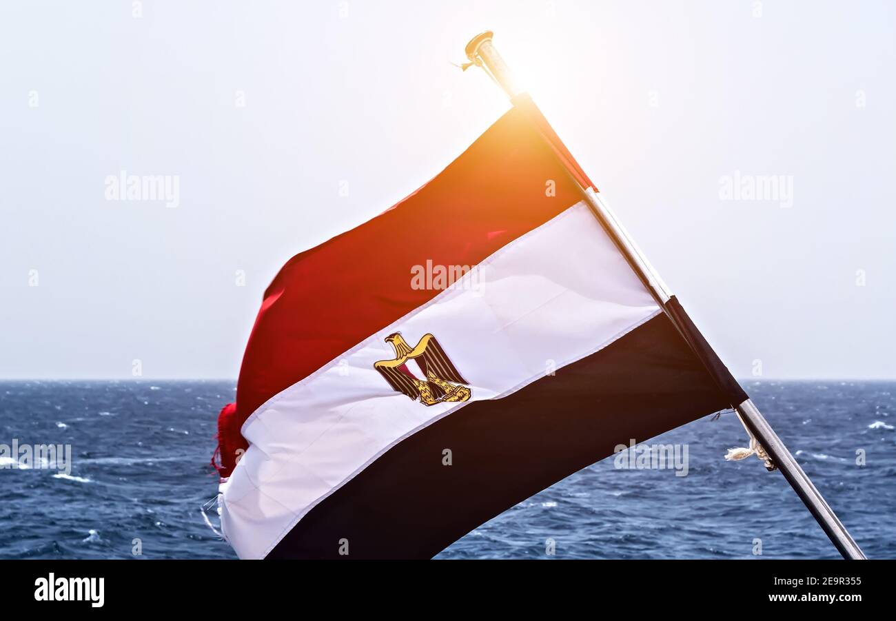 Egypt flag blowing in the wind of blue sky. Egyptian eagle of Saladin ...