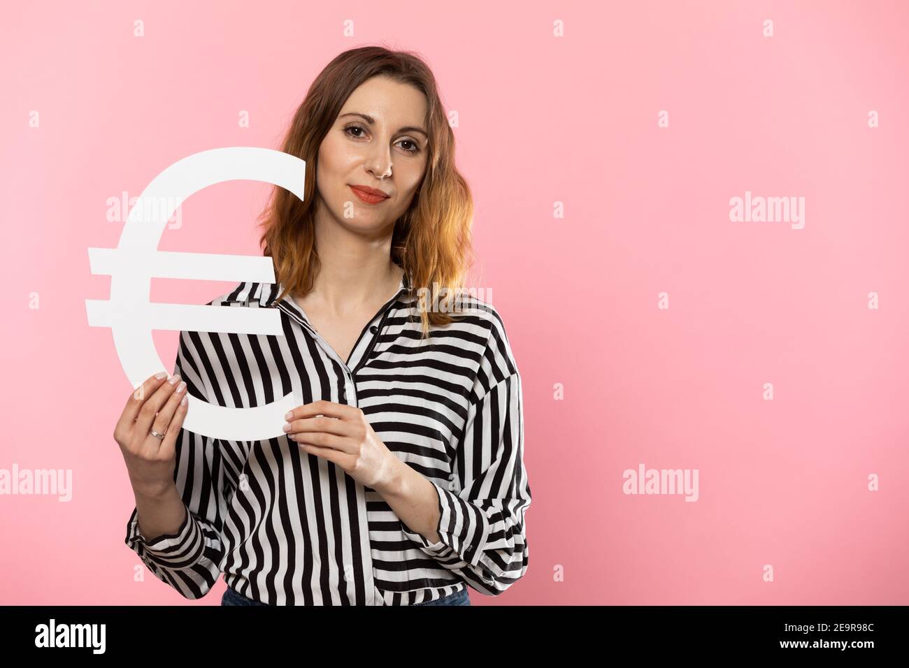 A symbol of the European currency held in the hands of a young girl ...