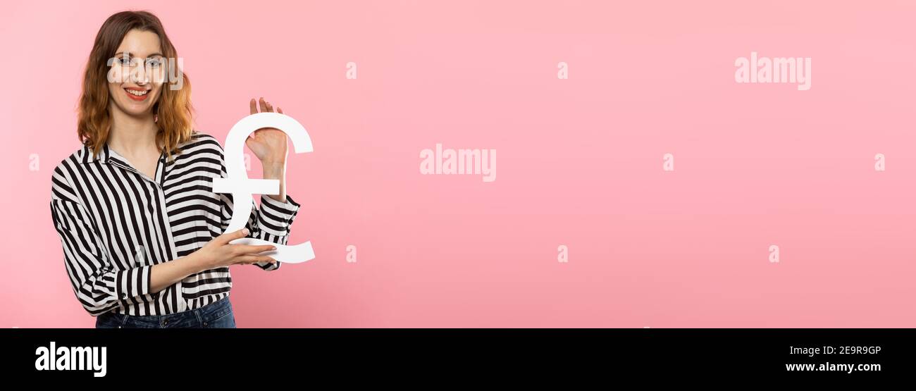 The pound currency symbol is held in the hands of a young girl ...