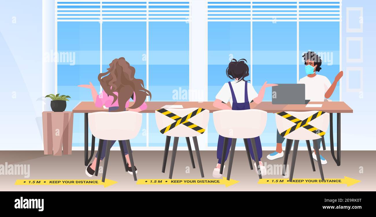 businesspeople sitting at round table keeping distance to prevent ...