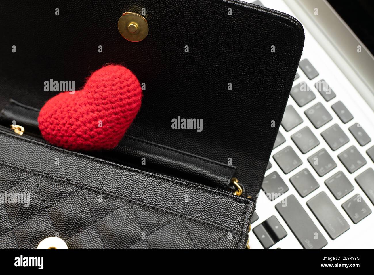 Love heart with the lady pouch or purse on laptop keyboard background ...