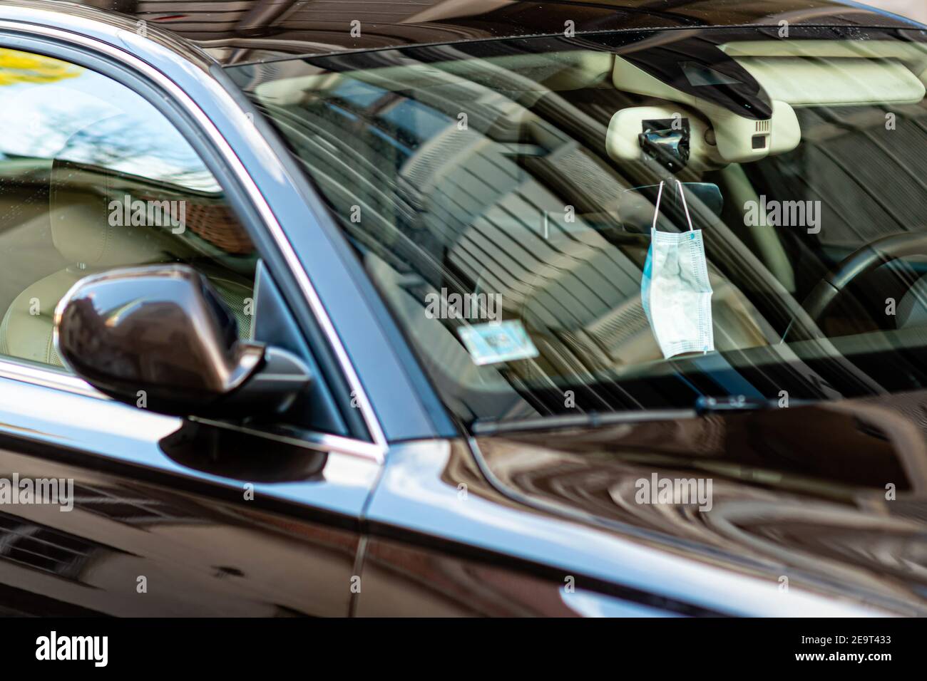 protective face mask hanging inside a car on the backmirror Stock Photo ...