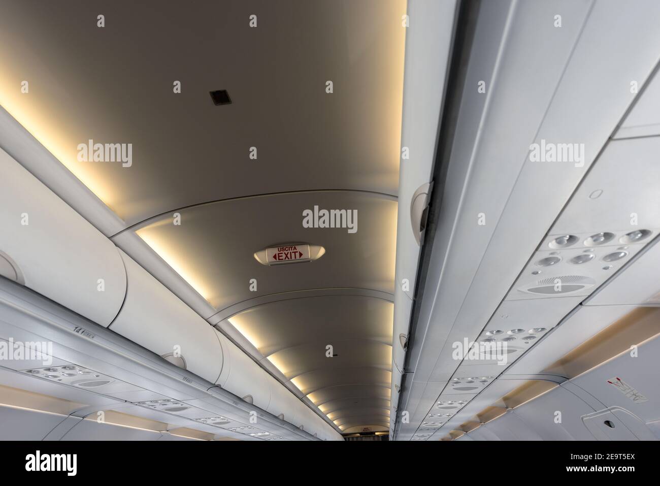 Emergency exit sign in the passenger cabin of an airplane in English ...