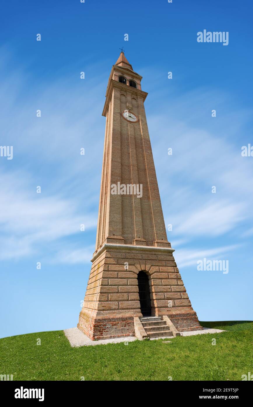 Old bell tower with a brick wall and clock of a church on blue sky with ...