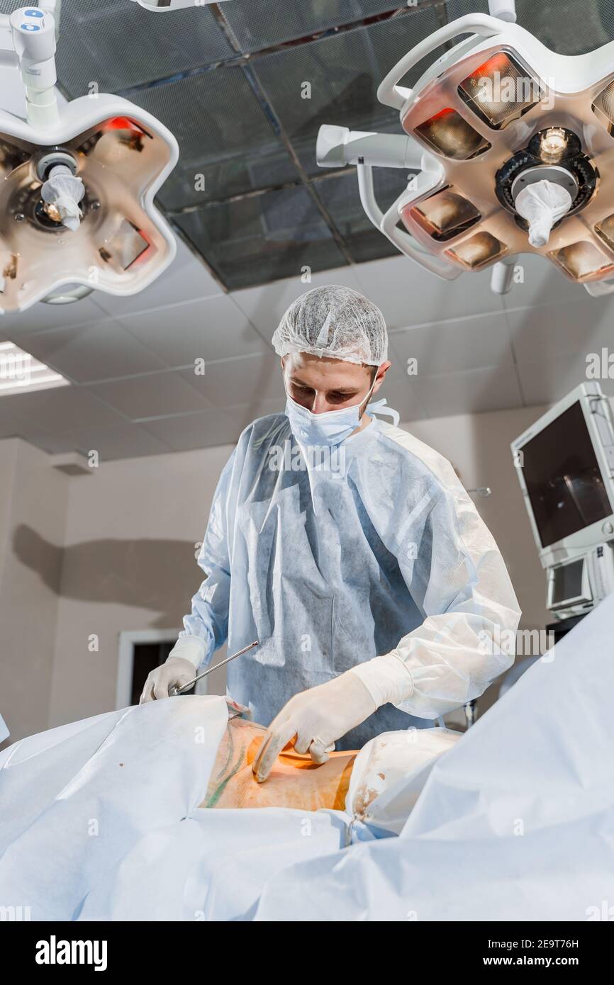 Surgeon removes fat in the gluteal region. Abdominoplasty - plastic ...