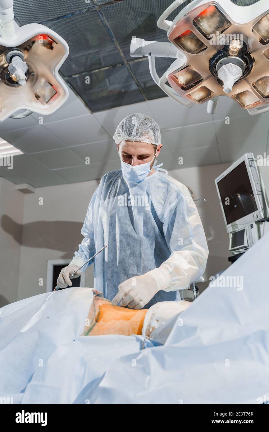 Surgeon removes fat in the gluteal region. Abdominoplasty - plastic ...