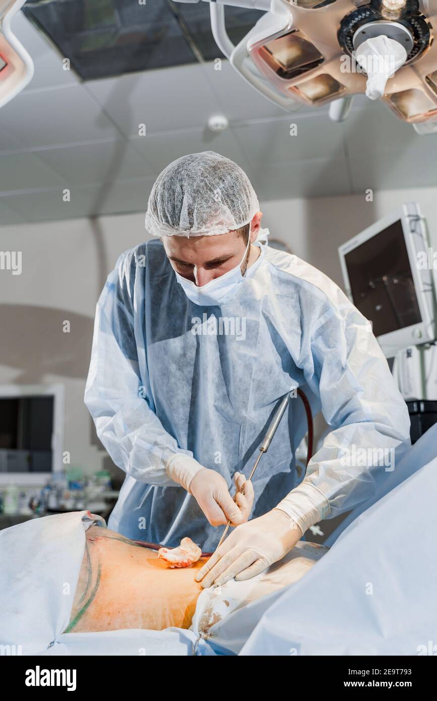 Surgeon removes fat in the gluteal region. Abdominoplasty - plastic ...