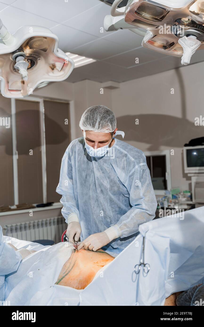 Surgeon removes fat in the gluteal region. Abdominoplasty - plastic ...