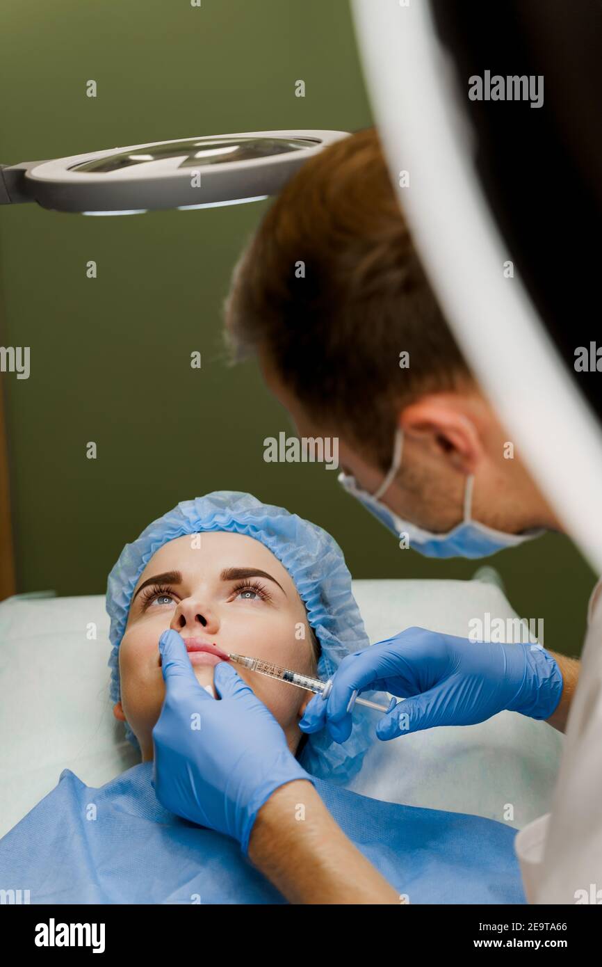 Lips augmentation injections for attractive girl. Plastic surgeon does ...