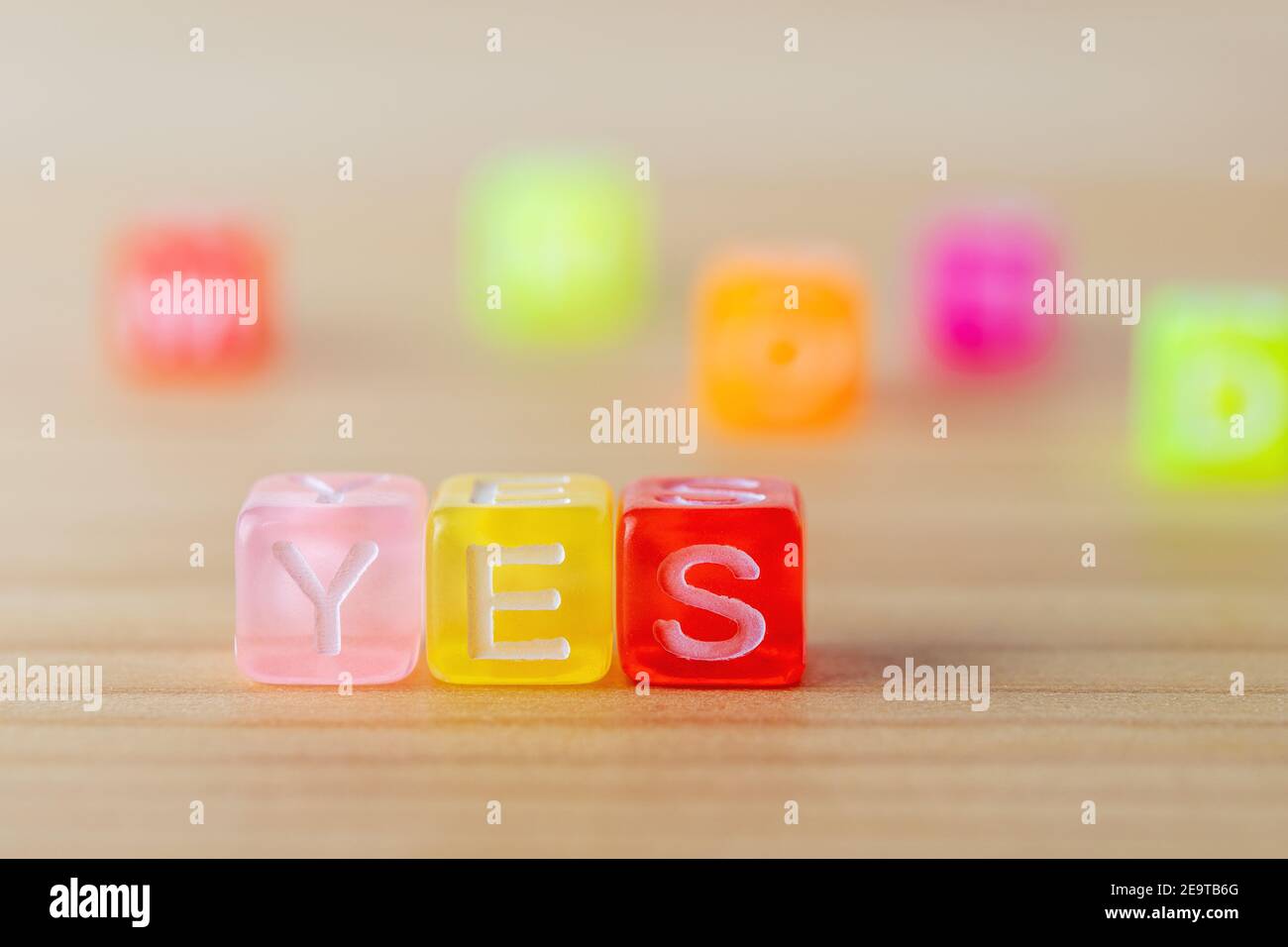YES text with color letters cubes on wooden background. Minimal concept ...