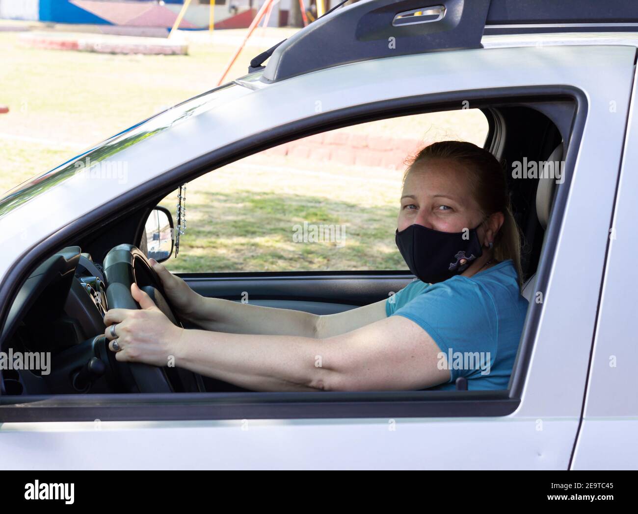 Woman with face mask driving her new car during coronavirus Stock Photo ...