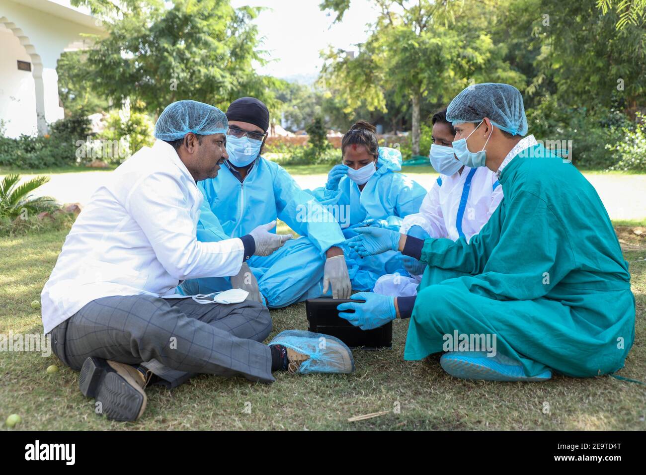 The Indian doctors having a discussion while sitting on green grass ...