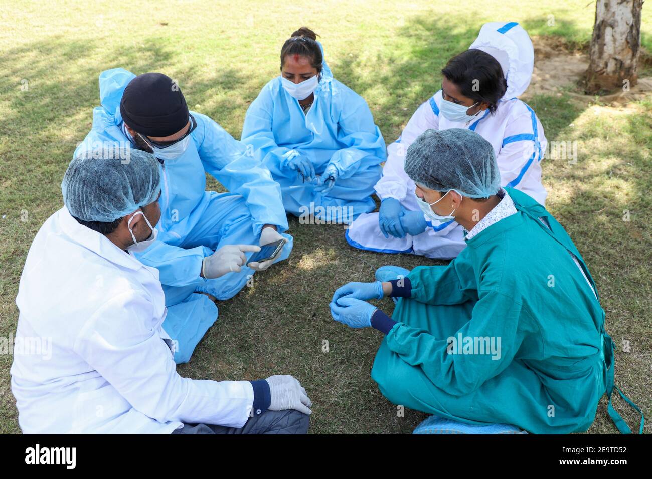 The Indian doctors having a discussion while sitting on green grass ...