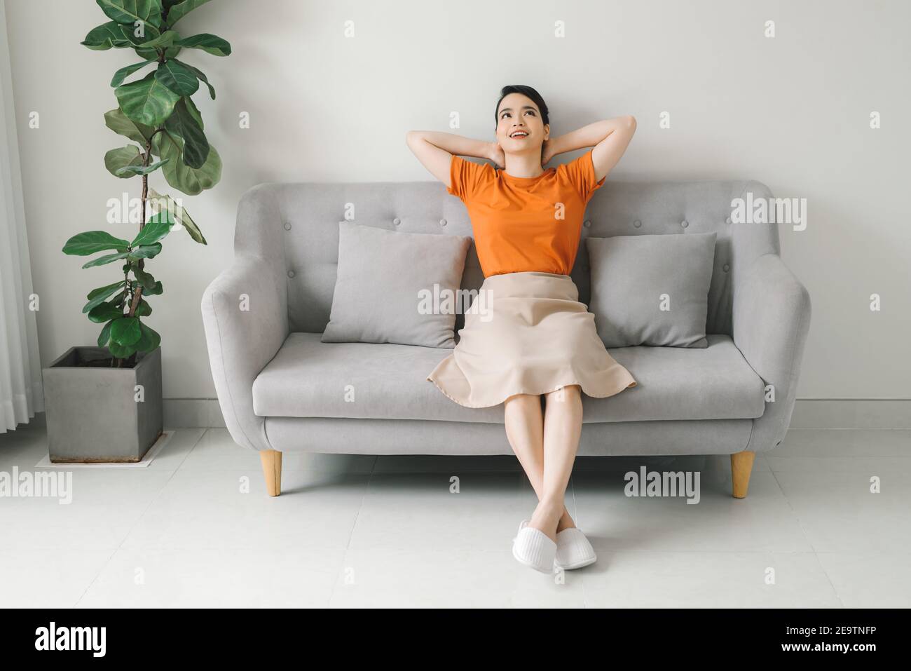 Finally weekends. Millennial girl relaxing at home on couch, enjoying ...