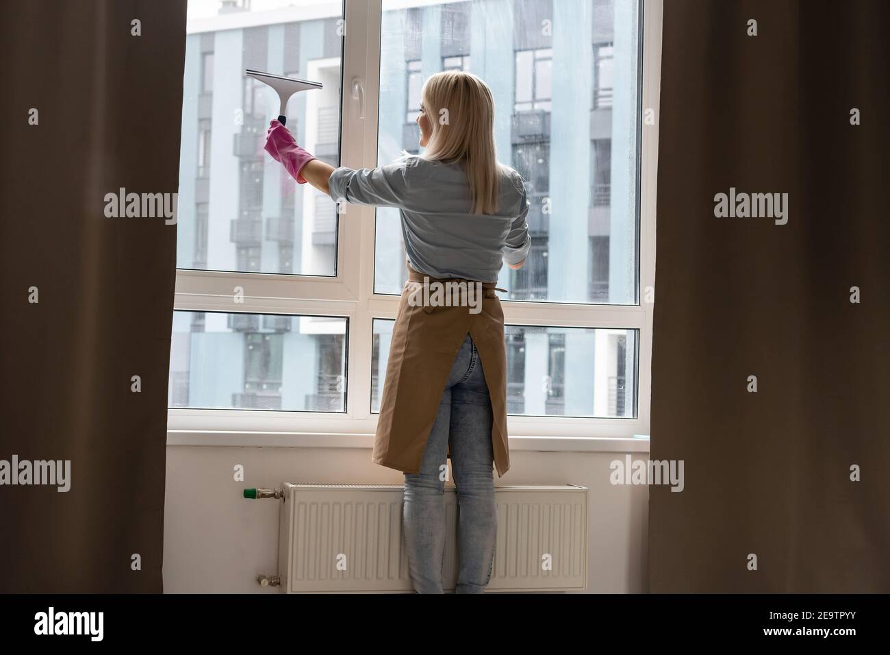 The woman washes a window in apartment Stock Photo - Alamy