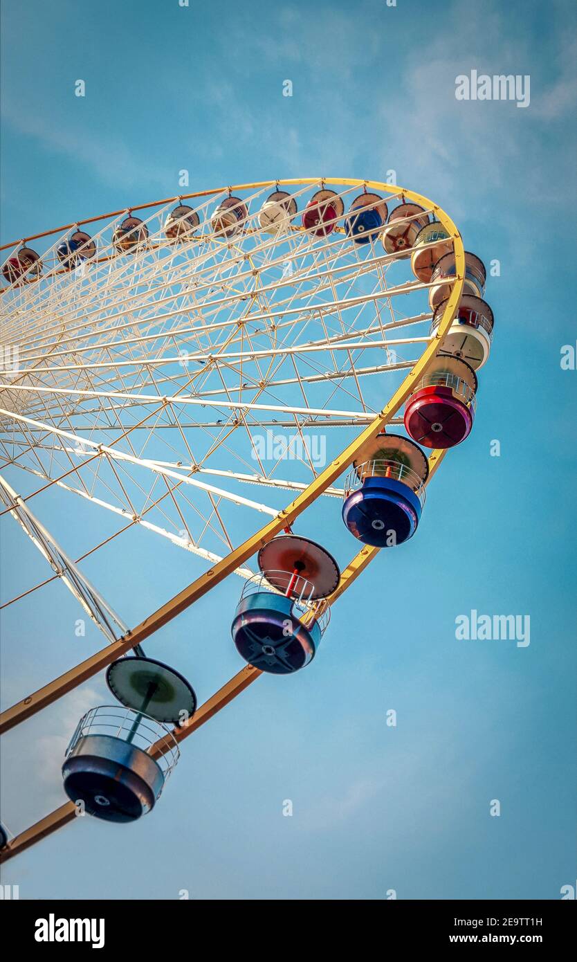 Vertical low angle shot of a Ferris wheel captured during the daytime ...