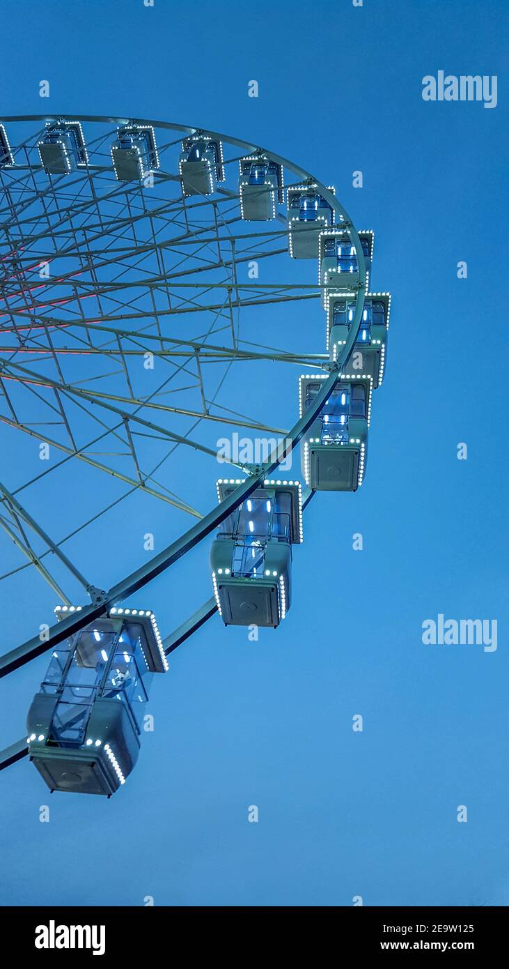 Vertical low angle shot of a Ferris wheel captured during the daytime ...
