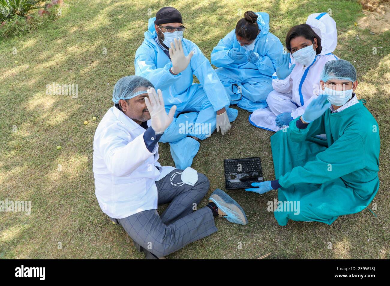 The Indian doctors with raised hands sitting on green grass - teamwork ...