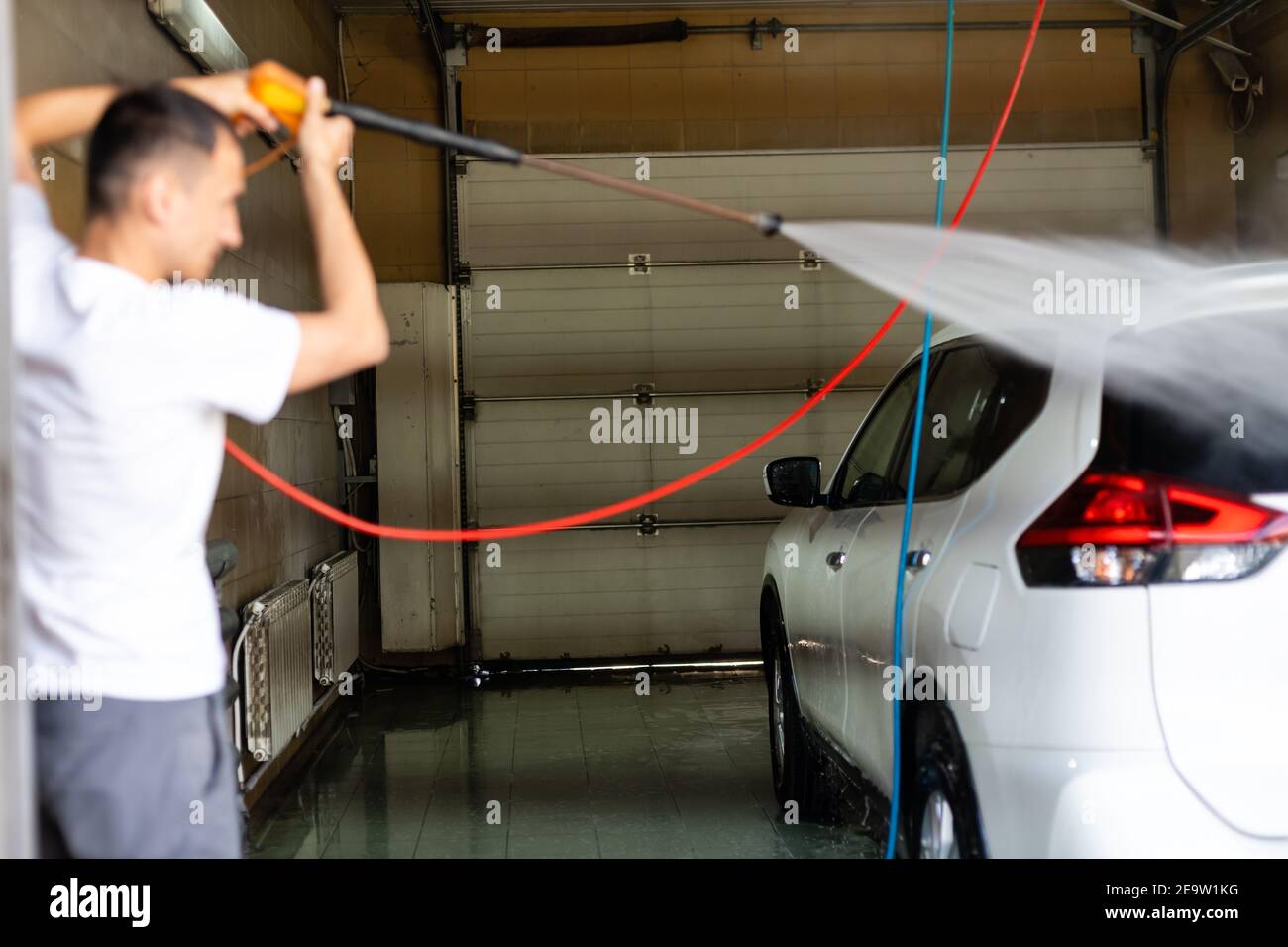 Young man spraying his car clean Stock Photo - Alamy