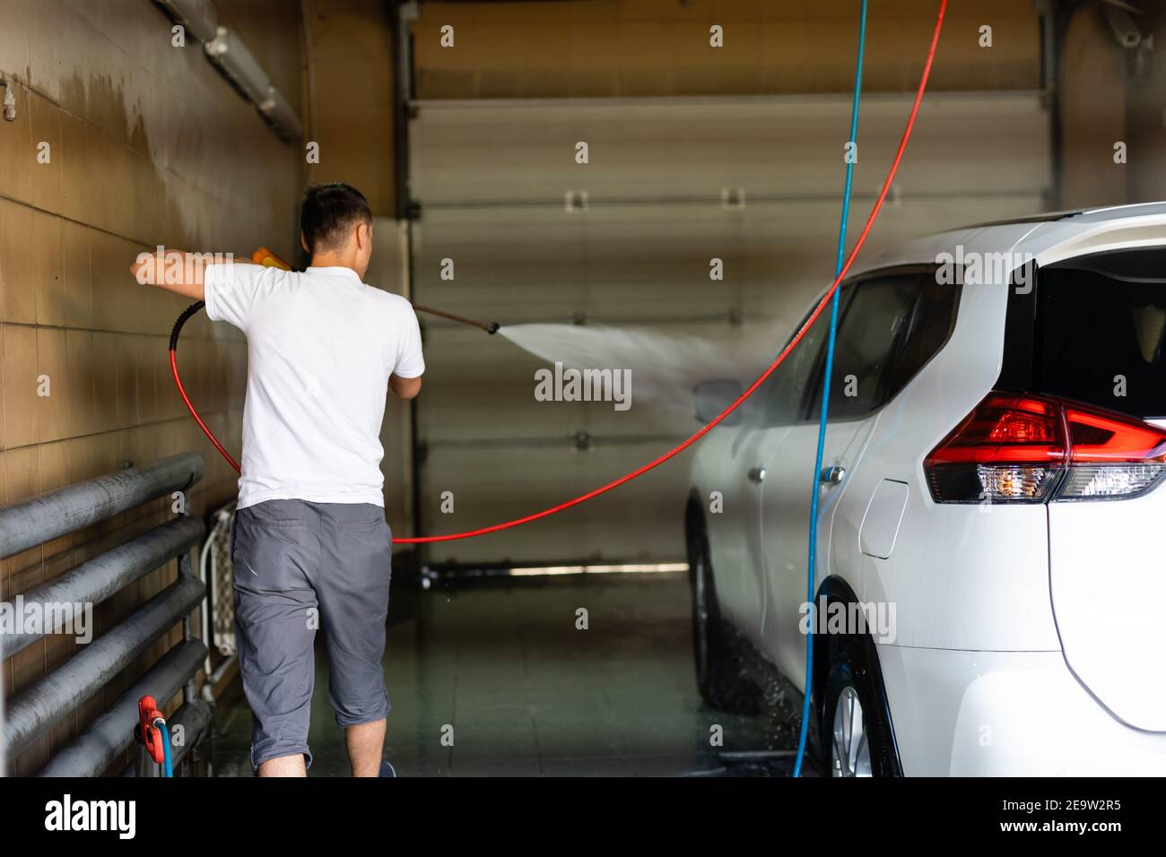 Young man spraying his car clean Stock Photo - Alamy
