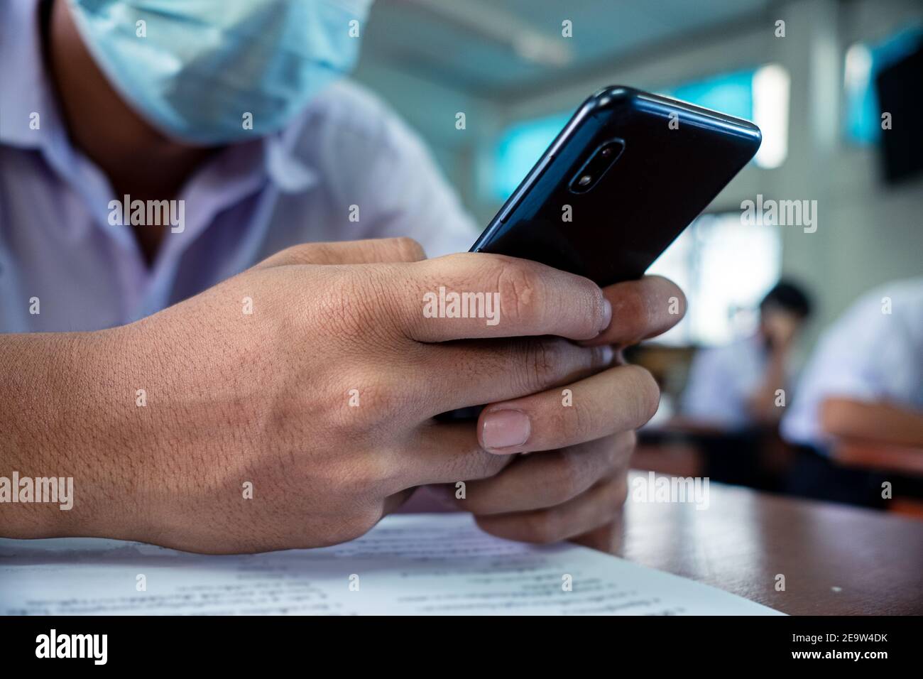 Uniform students are test exam and study online by using smartphone and ...