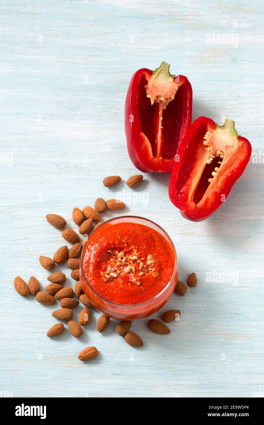 Homemade baked sweet bell pepper dip with almonds on a light blue ...