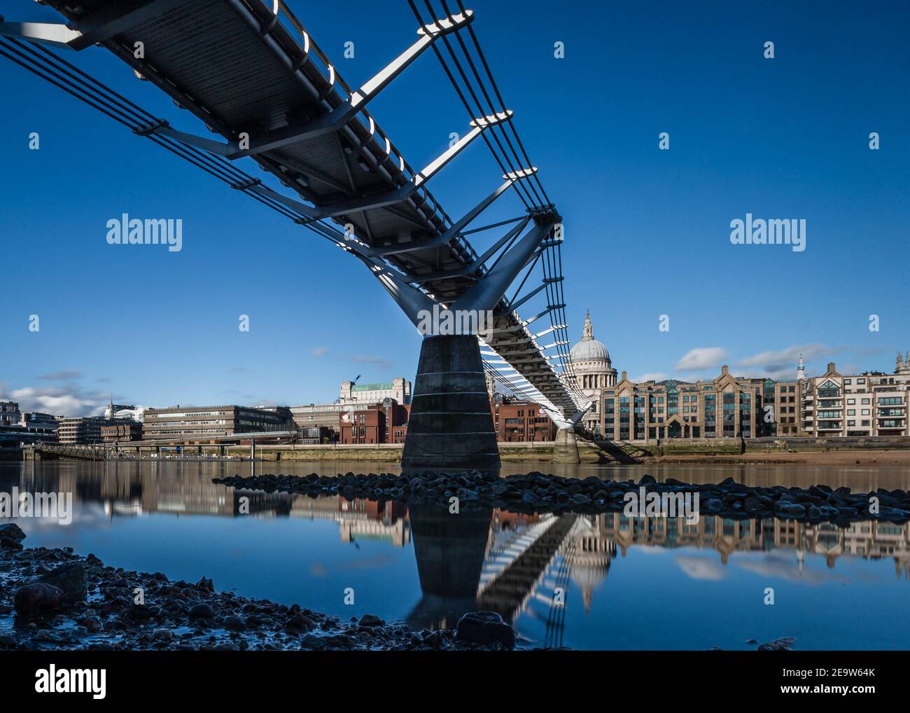 Reflection of the millennium bridge in the river thames in London ...