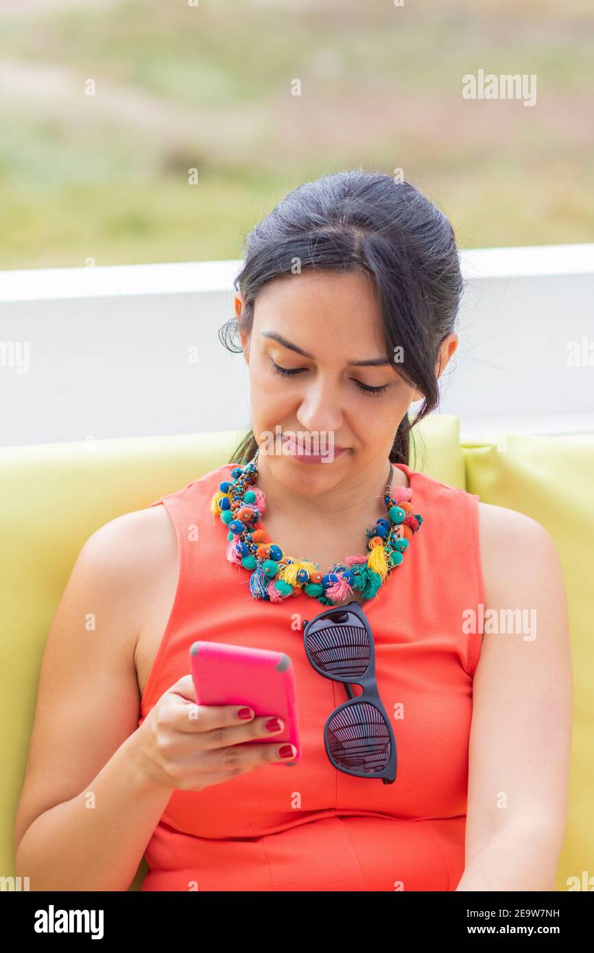 Pretty woman using her phone with bored face Stock Photo - Alamy
