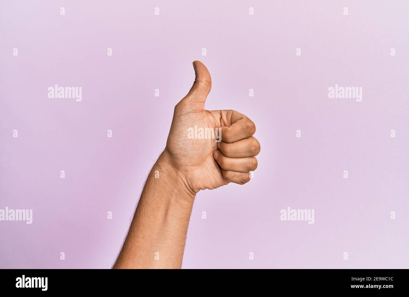 Arm and hand of caucasian young man over pink isolated background doing ...