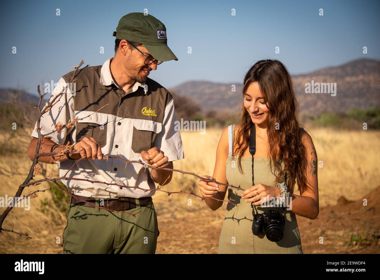 Safari guide showing woman branch in grassland Stock Photo - Alamy