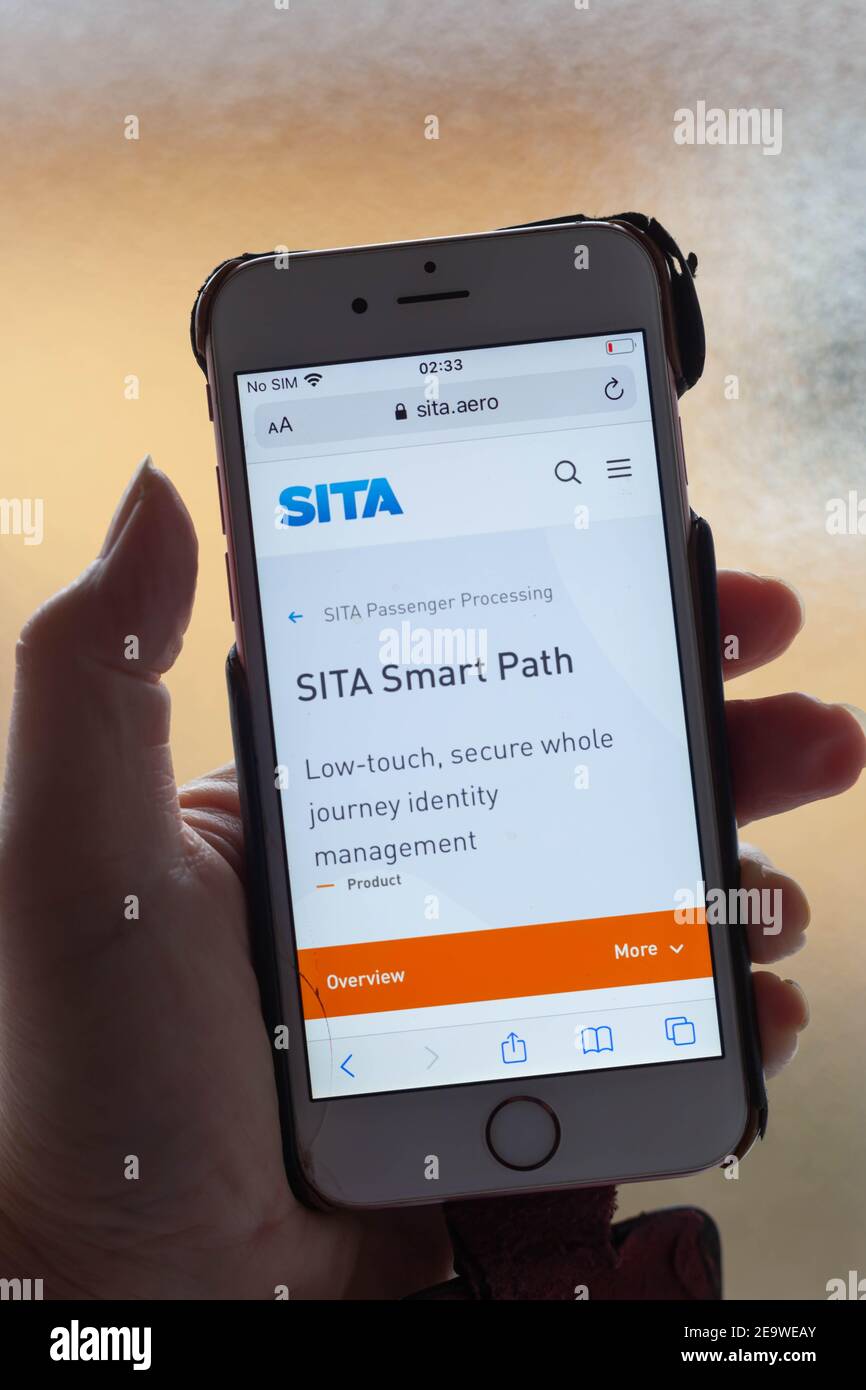 Close-up of a hand holding a mobile phone with SITA Smart Path travel ...