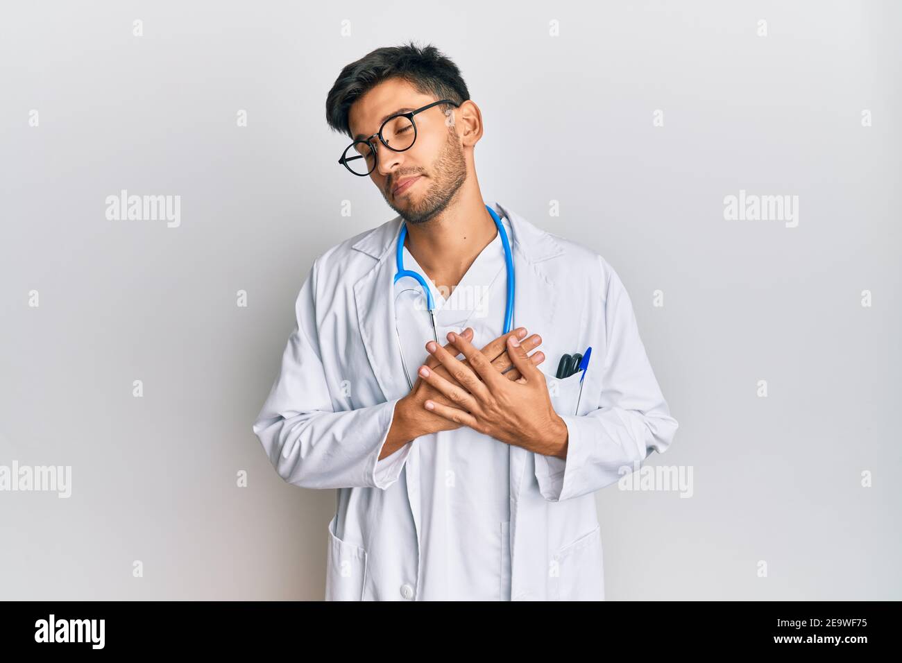 Young handsome man wearing doctor uniform and stethoscope smiling with ...