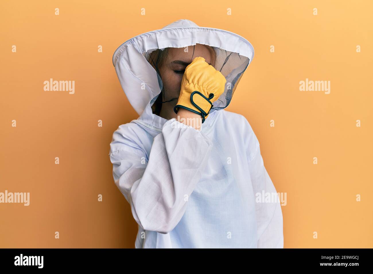 Beautiful blonde caucasian woman wearing protective beekeeper uniform ...