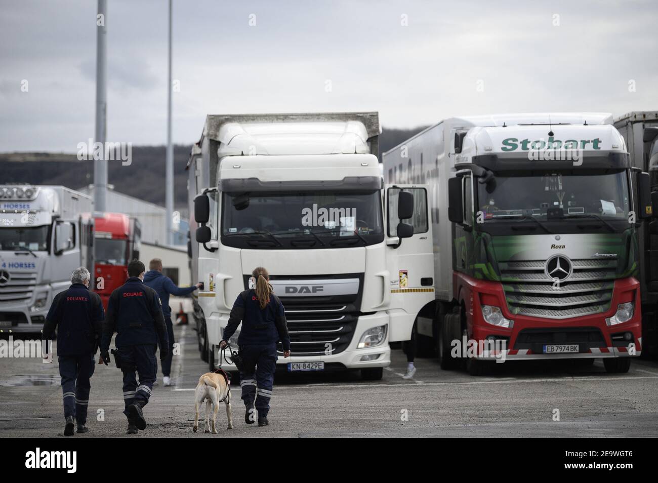 French Customs officers look on trucks arriving for embarkation at the ...