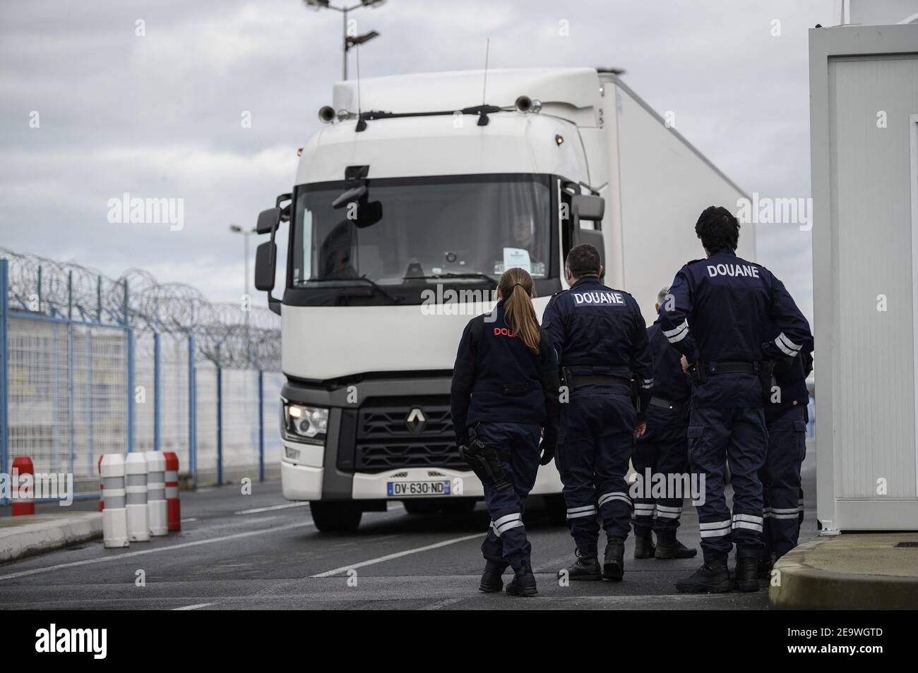 French Customs officers look on trucks arriving for embarkation at the ...