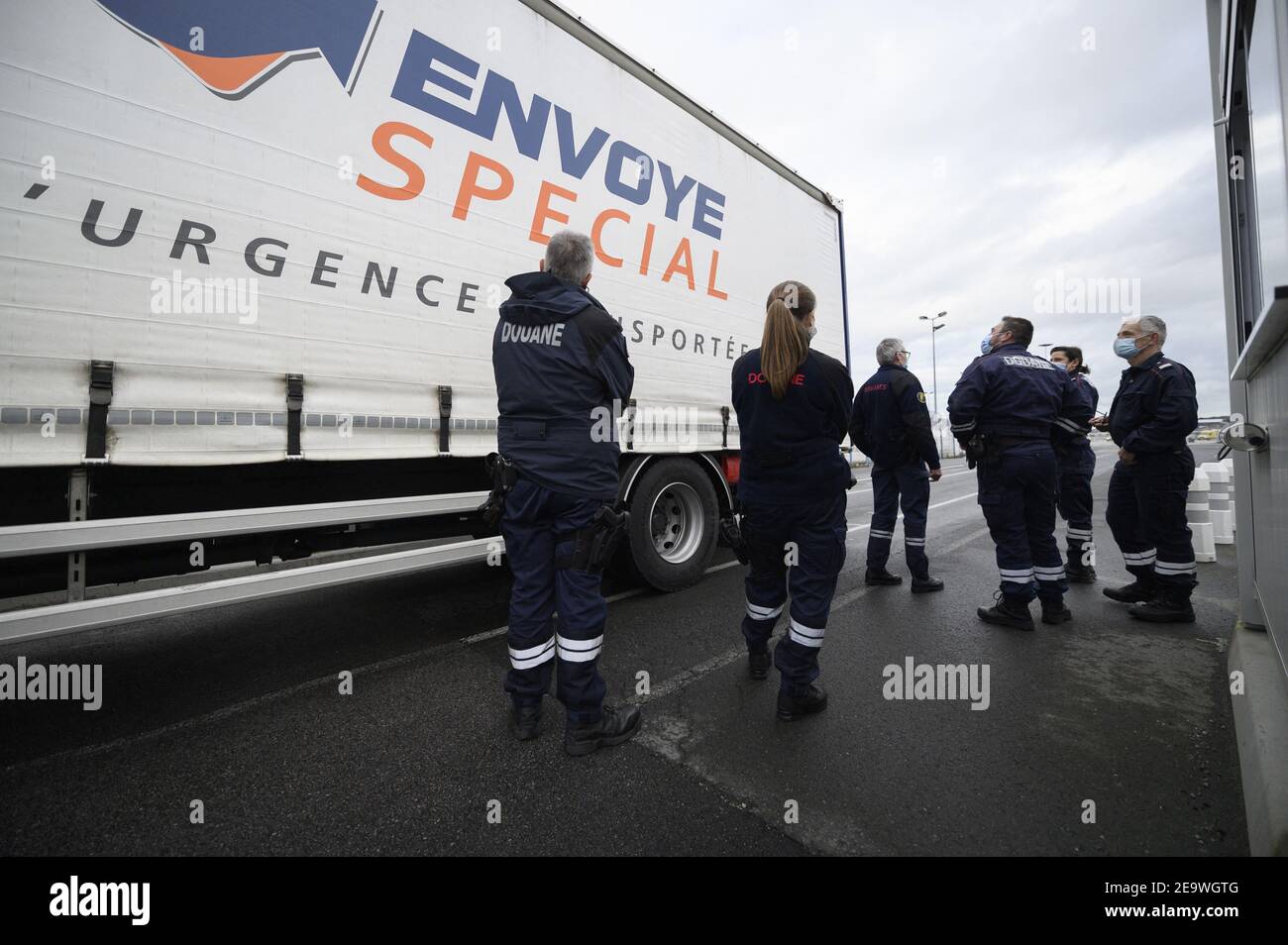 French Customs officers look on trucks arriving for embarkation at the ...